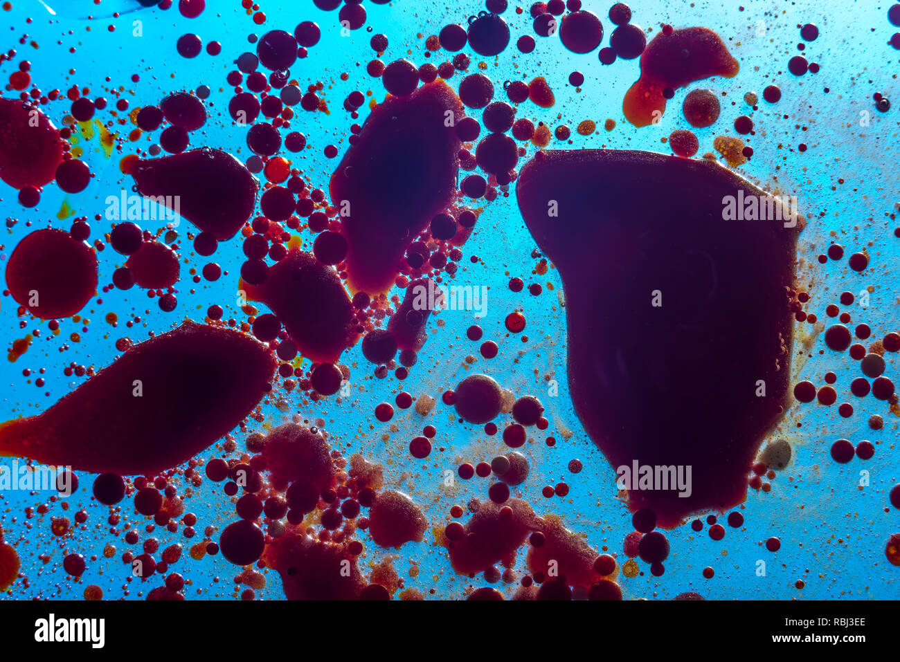 Red bubbles of blood cells on a blue background closeup. Abstraction of ...