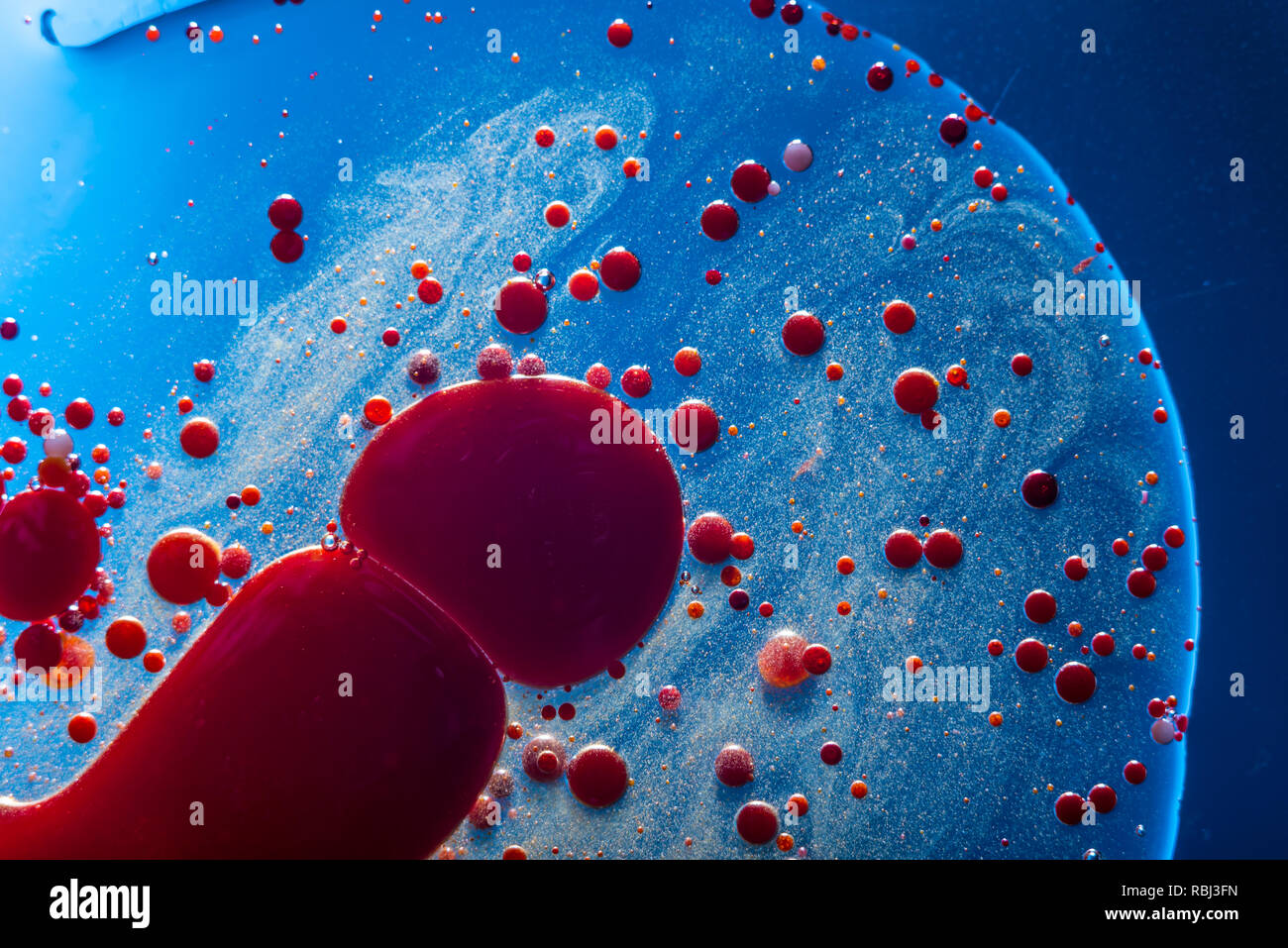 Red bubbles of blood cells on a blue background closeup. Abstraction of ...