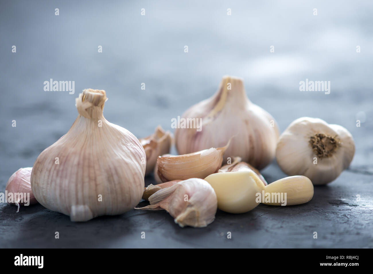 Group of garlic cloves scattered on a table on a white background. An ...