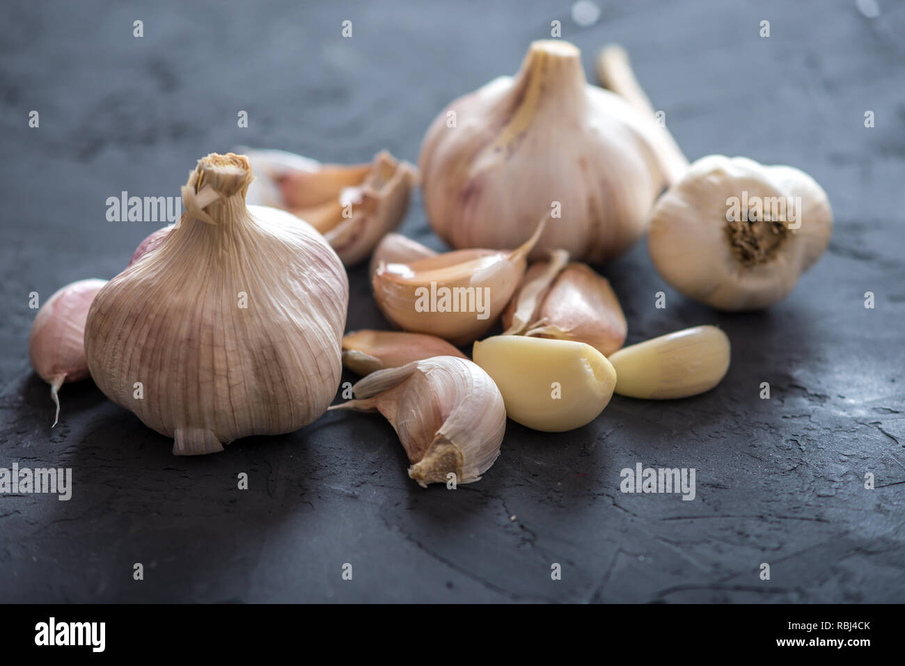 Group of garlic cloves scattered on a table on a white background. An ...