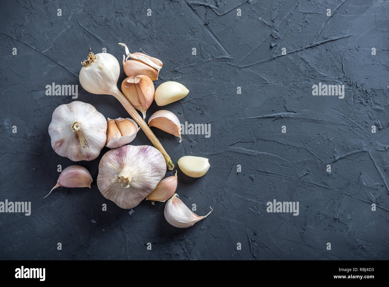 Group of garlic cloves scattered on a table on a white background. An ...