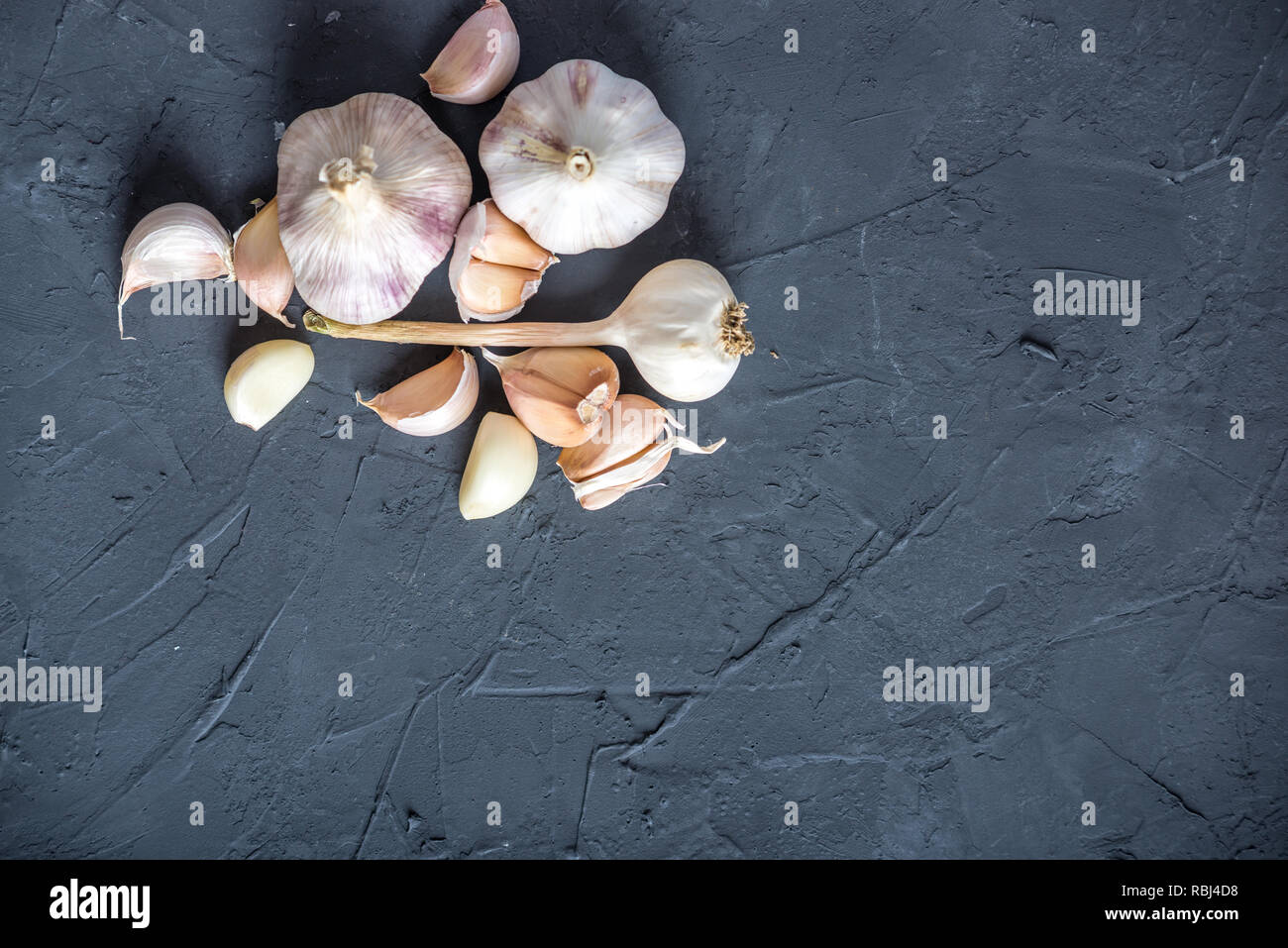 Group of garlic cloves scattered on a table on a white background. An ...