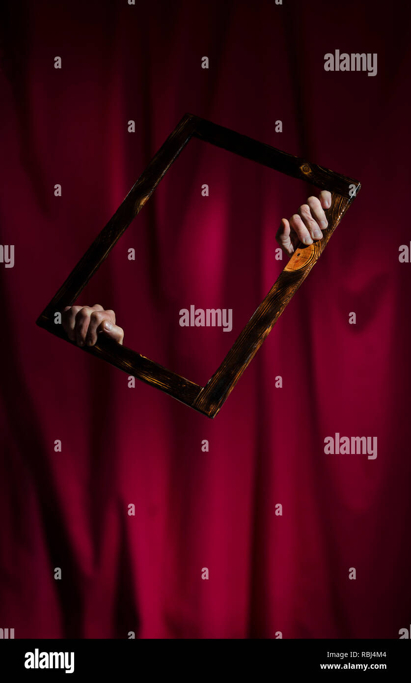 Hands of a man trying to get out of the frame on a red background Stock ...