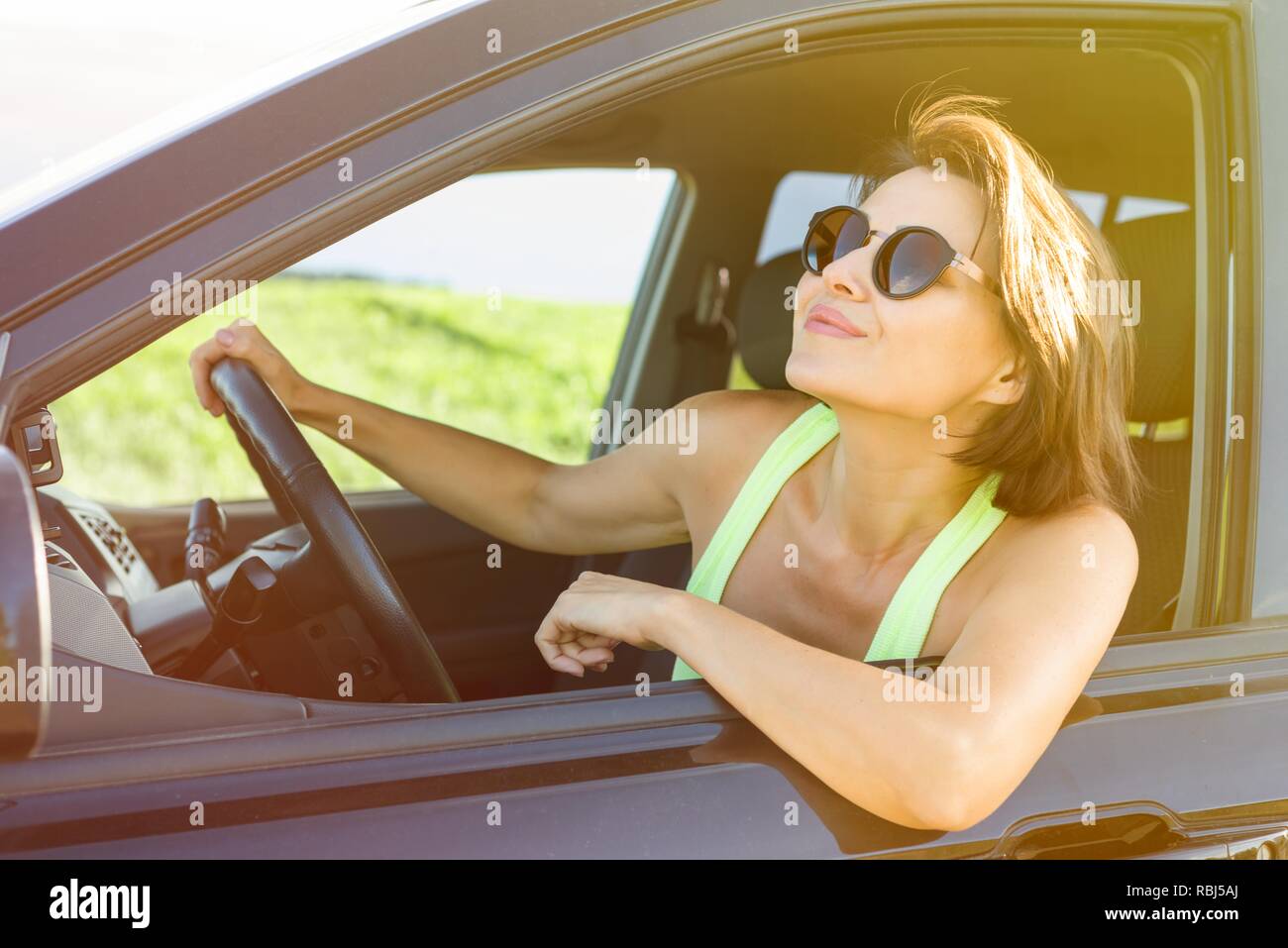 Beautiful female driver smiling while driving his car Stock Photo - Alamy
