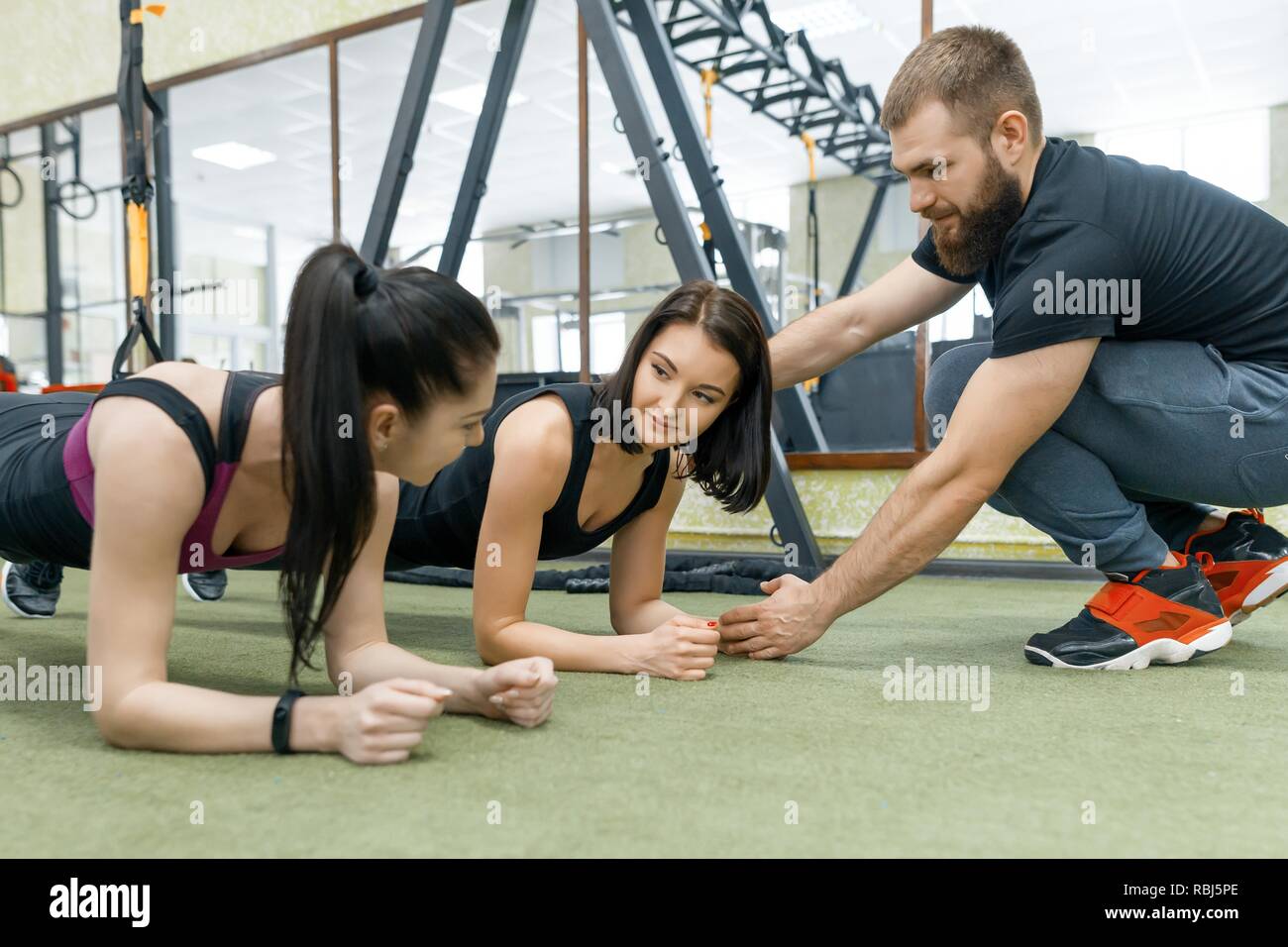 Personal fitness trainer coaching and helping client woman making ...