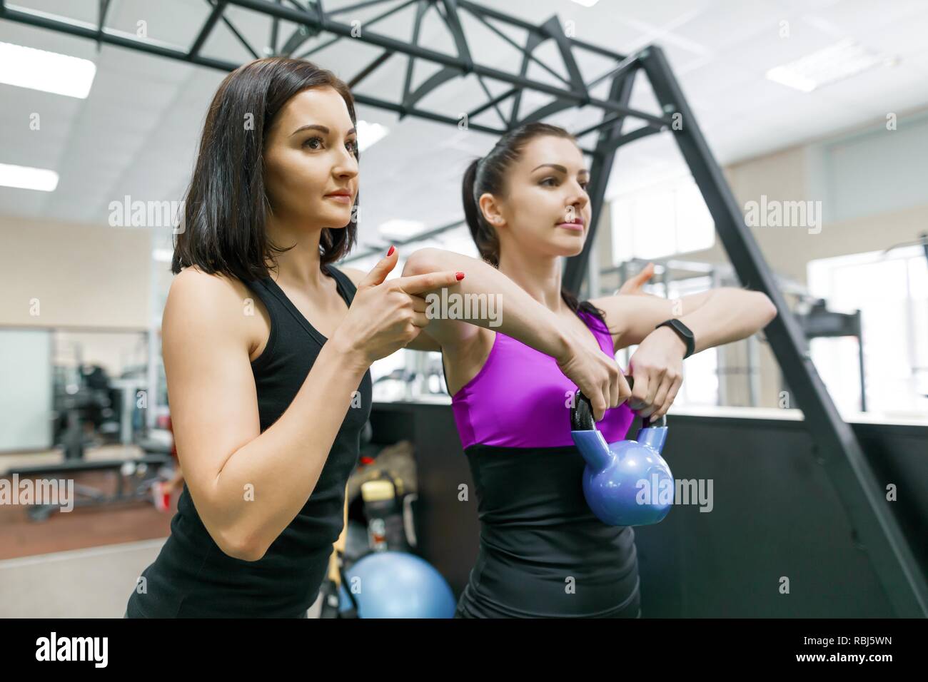 Personal fitness trainer coaching and helping client woman making ...