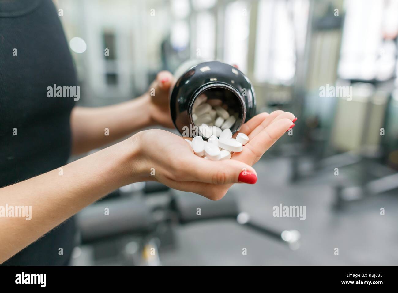 Closeup of fitness woman hands showing sports and fitness supplements ...
