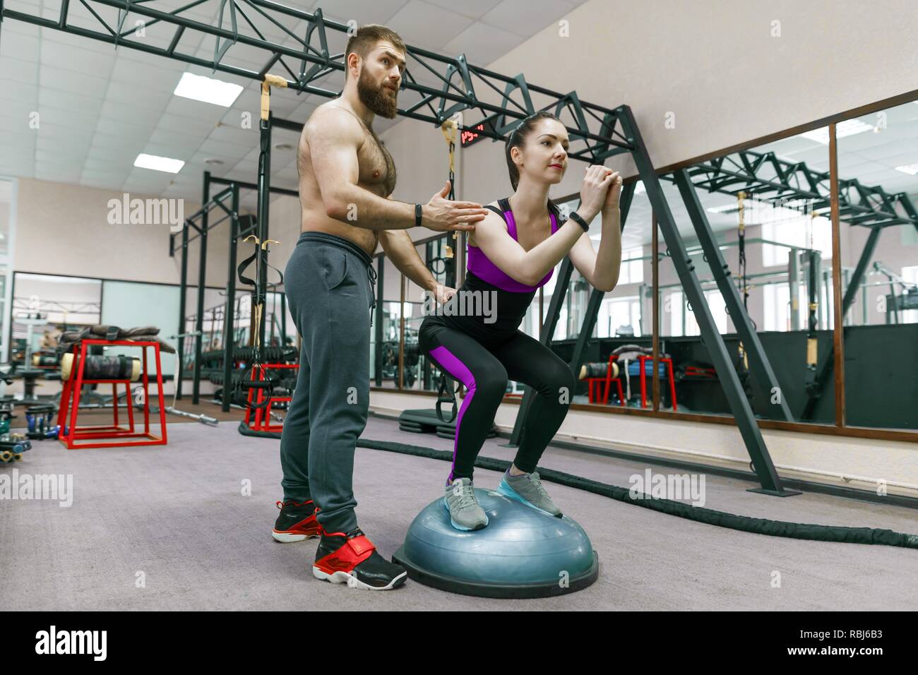 Personal fitness trainer coaching and helping client woman making ...