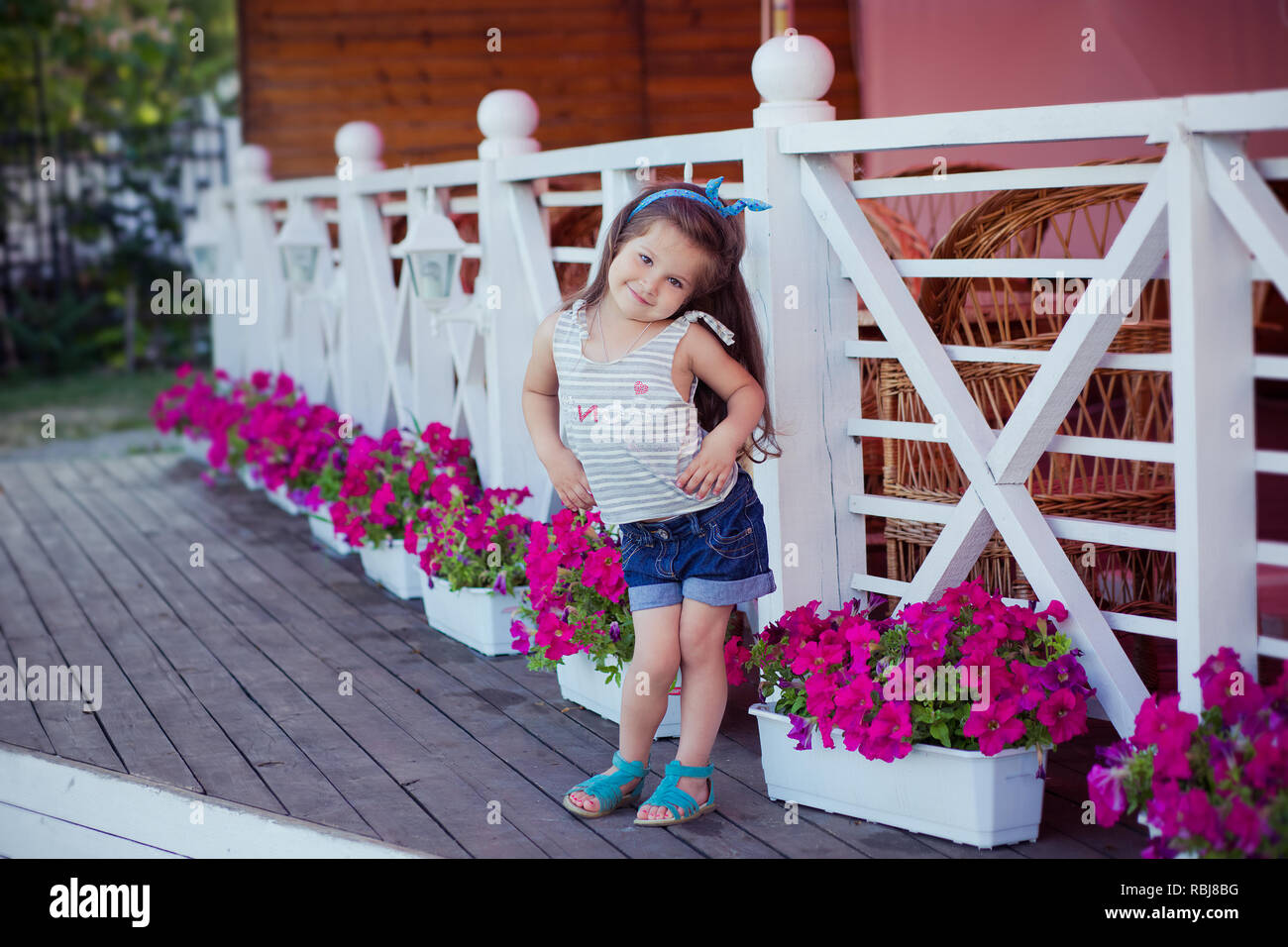 Stylish beautifull cute baby girl with brunette hair posing on wooden ...