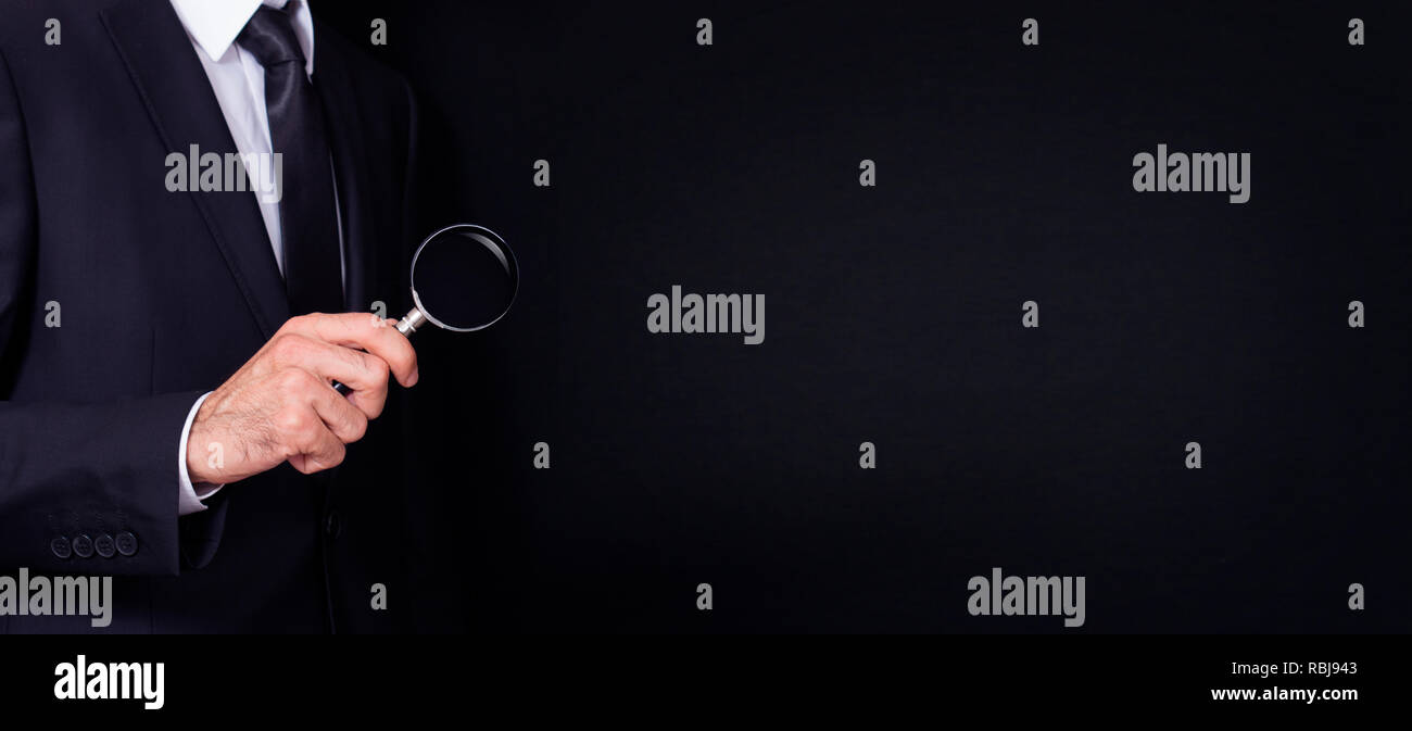 suit businessman holding a magnifying glass Stock Photo - Alamy