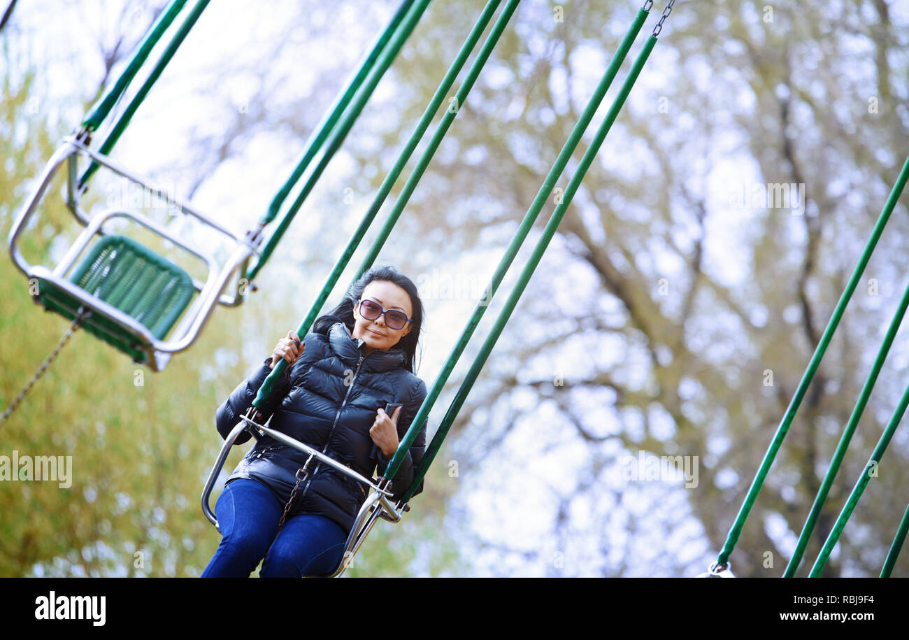 Woman riding on the chain swing at amuzement park Stock Photo - Alamy