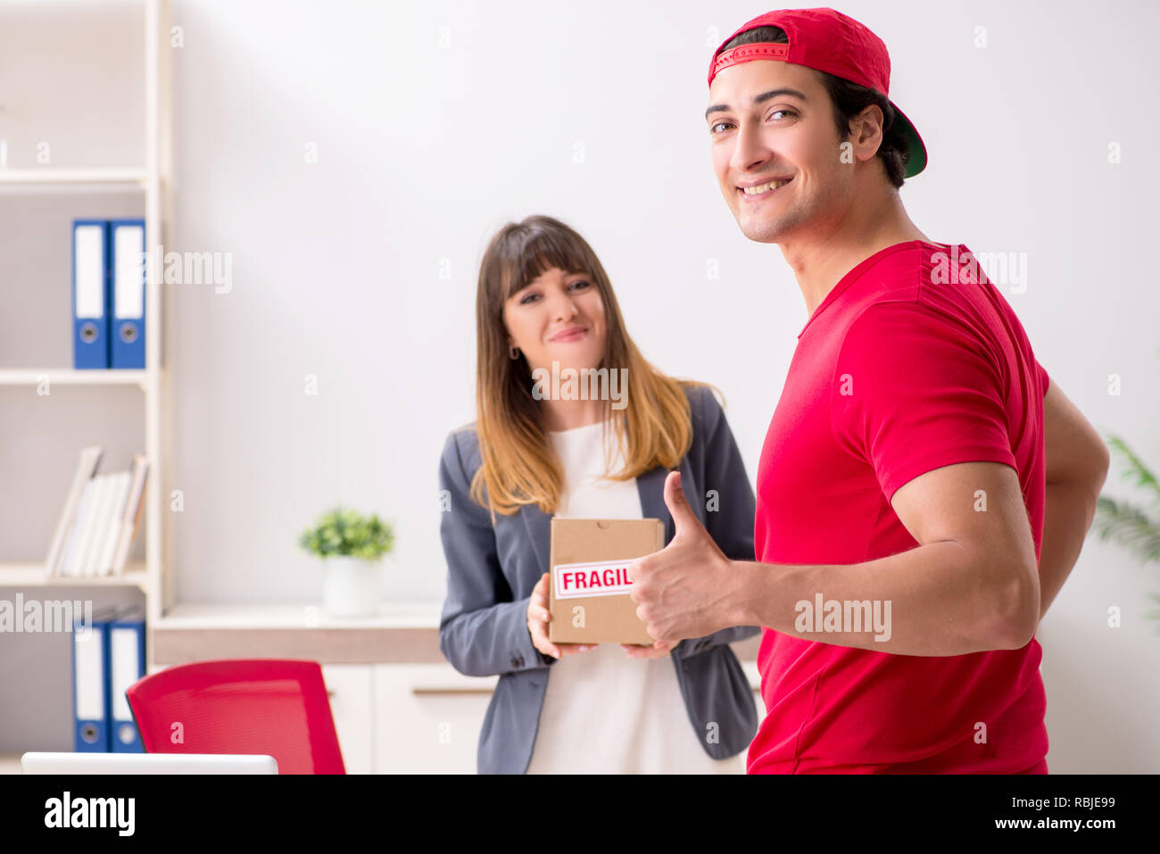 Courier delivering parcel to the office Stock Photo - Alamy