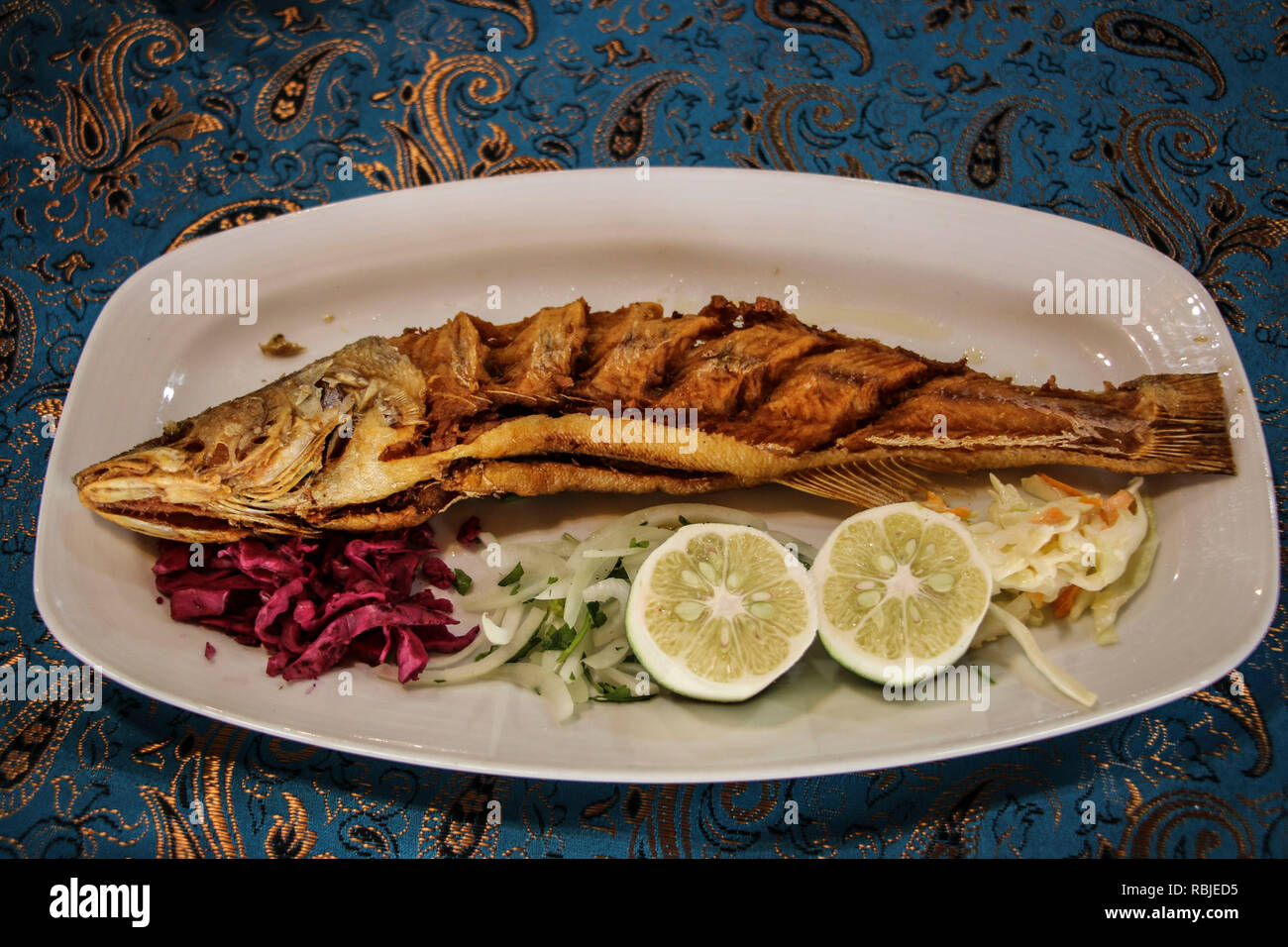 Fish dish cooking with various ingredients with lemon, garlic, herbs ...