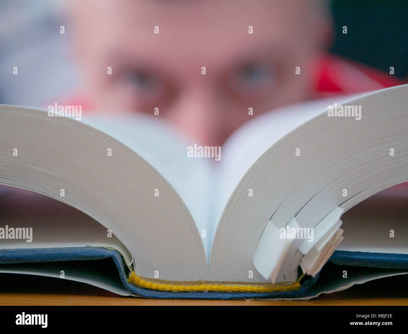 opened book with blurred out of focus face on background. closeup macro ...
