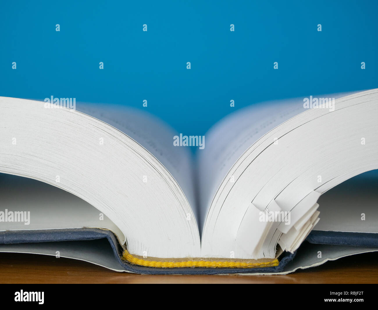 closeup of opened book binding with blue background and lot of copy ...