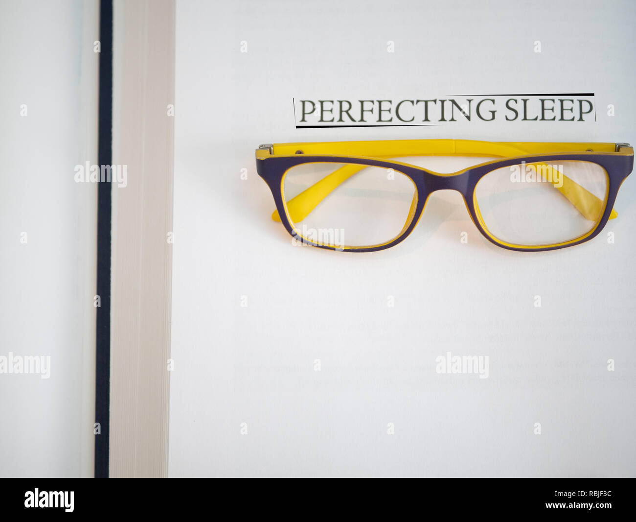reading glasses lay on opened book chapter named perfecting sleep. read ...