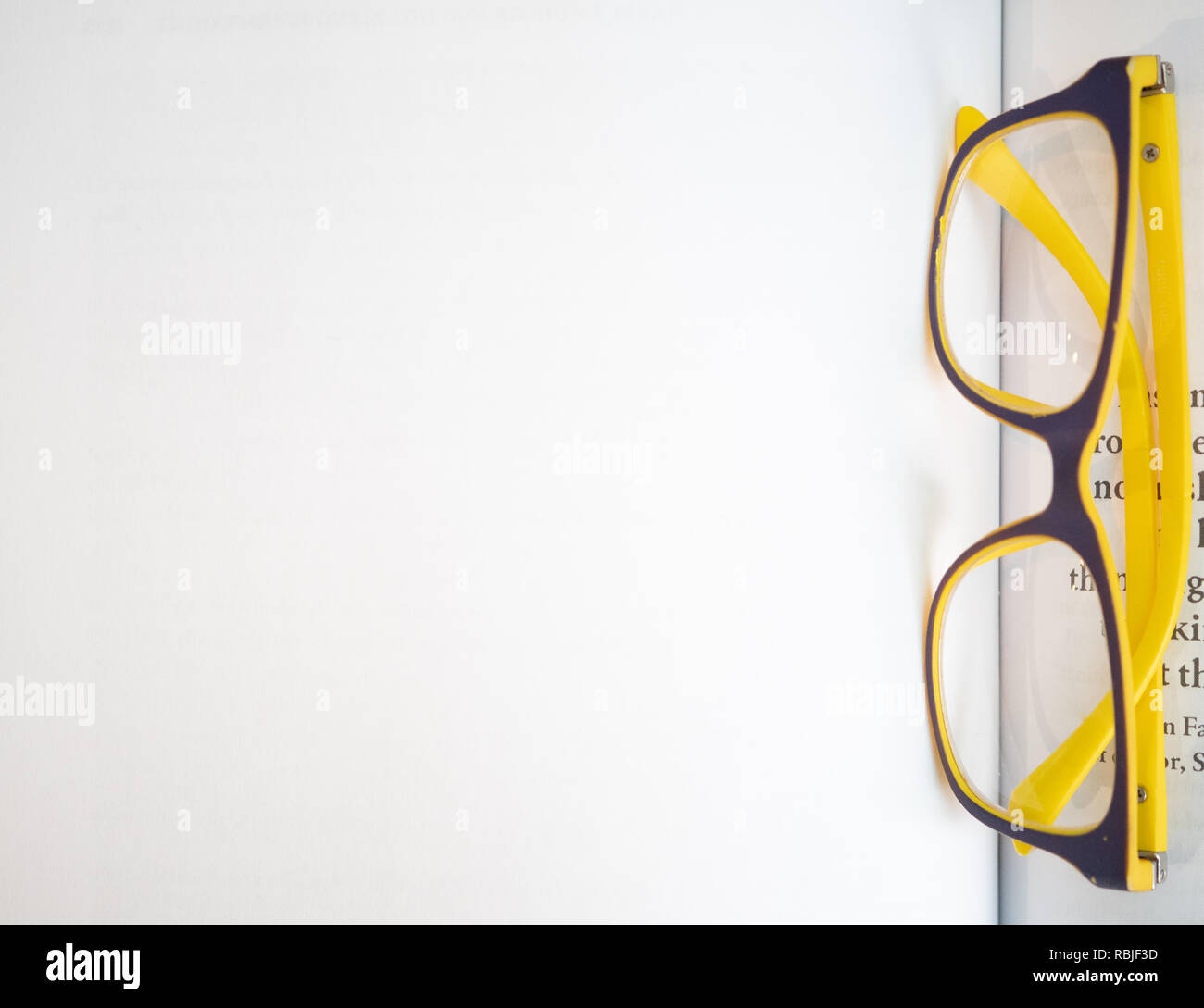 reading glasses lay on book spread on empty sheet blank page, view from ...