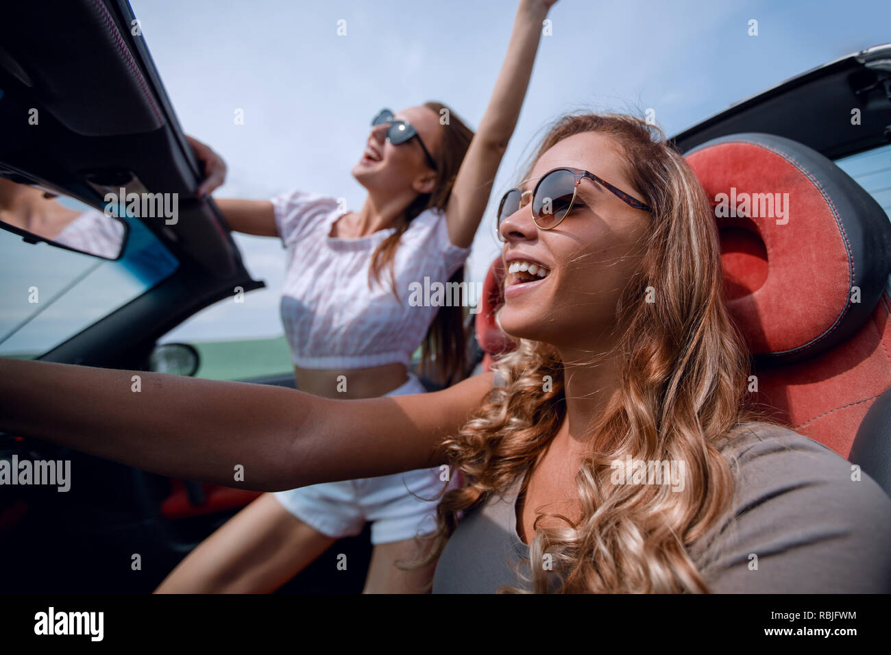 Two young women driving white hi-res stock photography and images - Alamy
