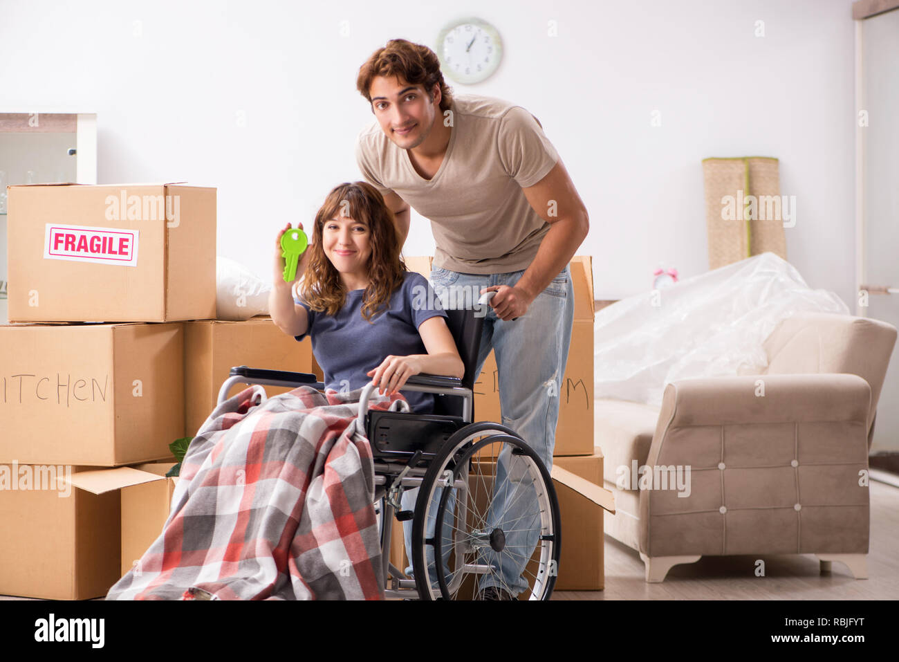 Husband with disabled wife moving to new flat Stock Photo - Alamy