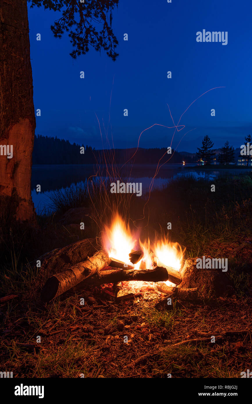 camp fire near lake Stock Photo - Alamy
