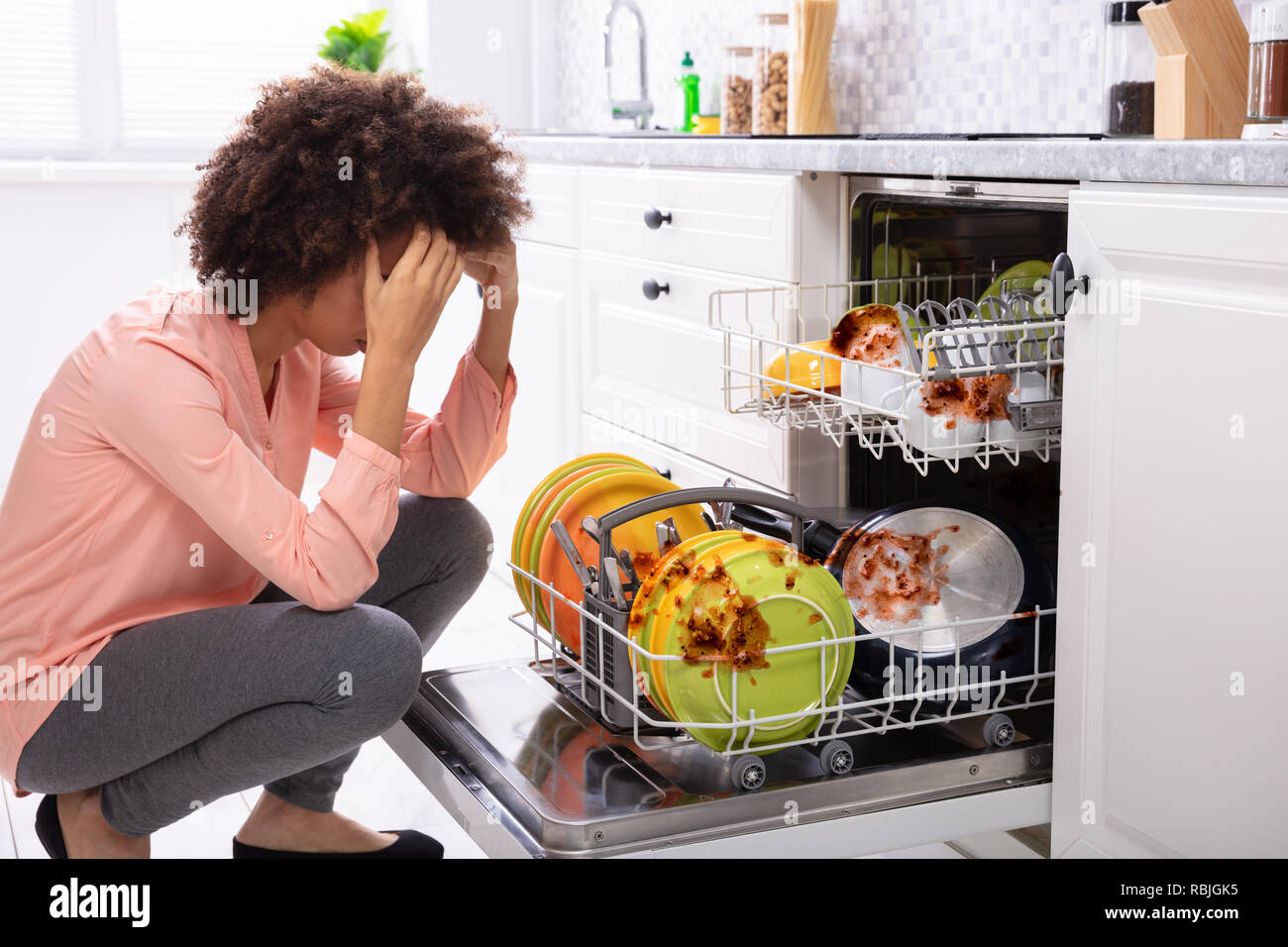 Worried Young Woman Looking At The Dirty Colorful Plates Arranged In ...