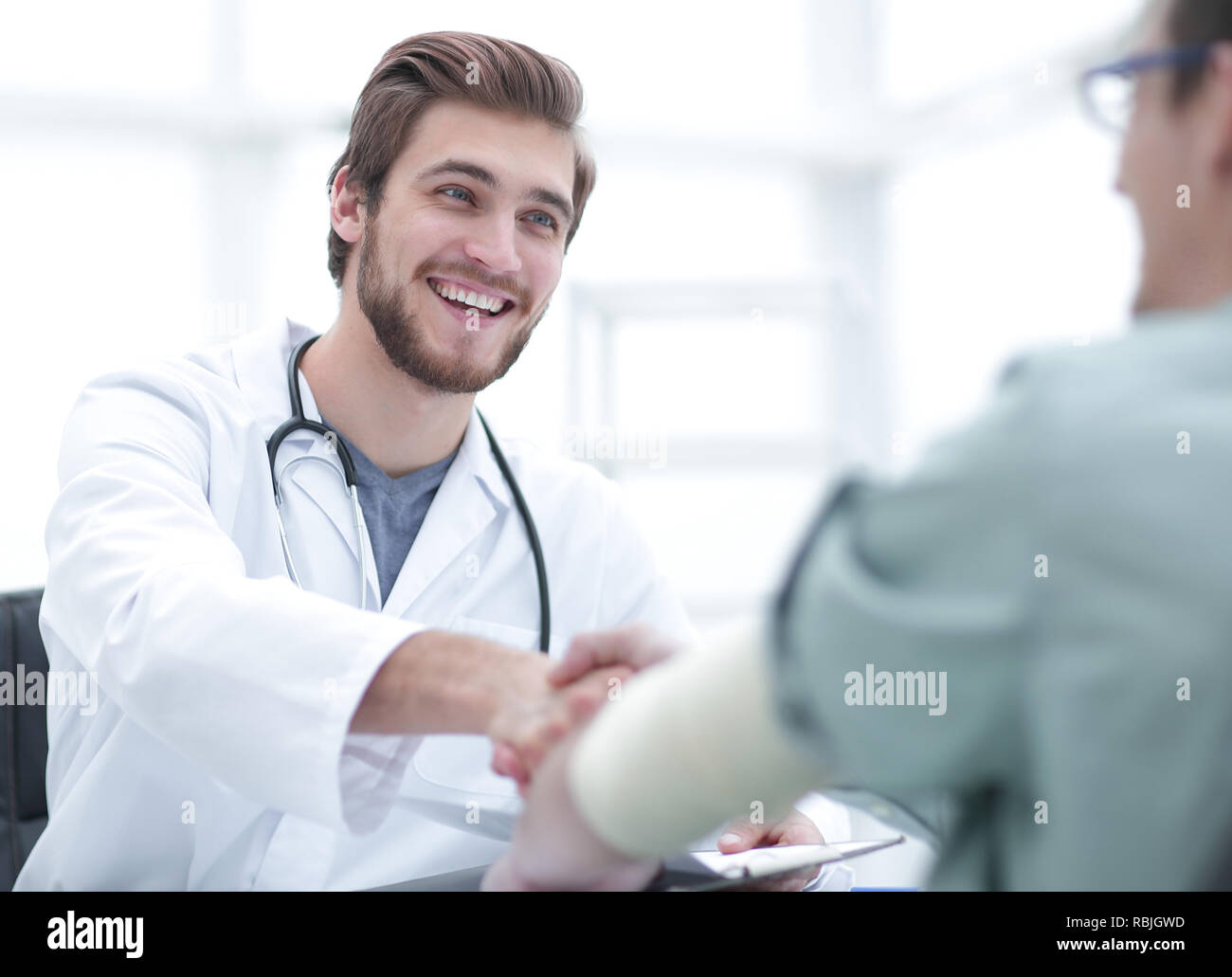 Doctor welcoming a patient in his studio Stock Photo - Alamy