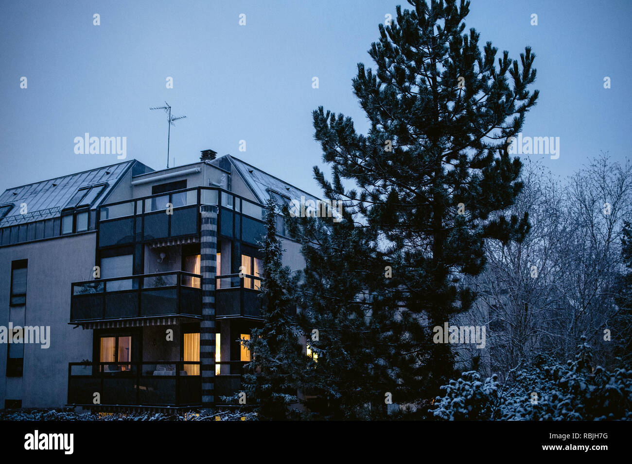 Modern apartment house with one light turned on the second and third ...