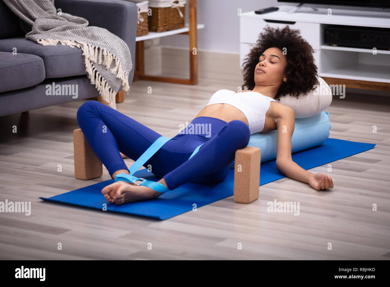 Relaxed Young Woman Lying On Fitness Mat Doing Exercise With Yoga Belt ...