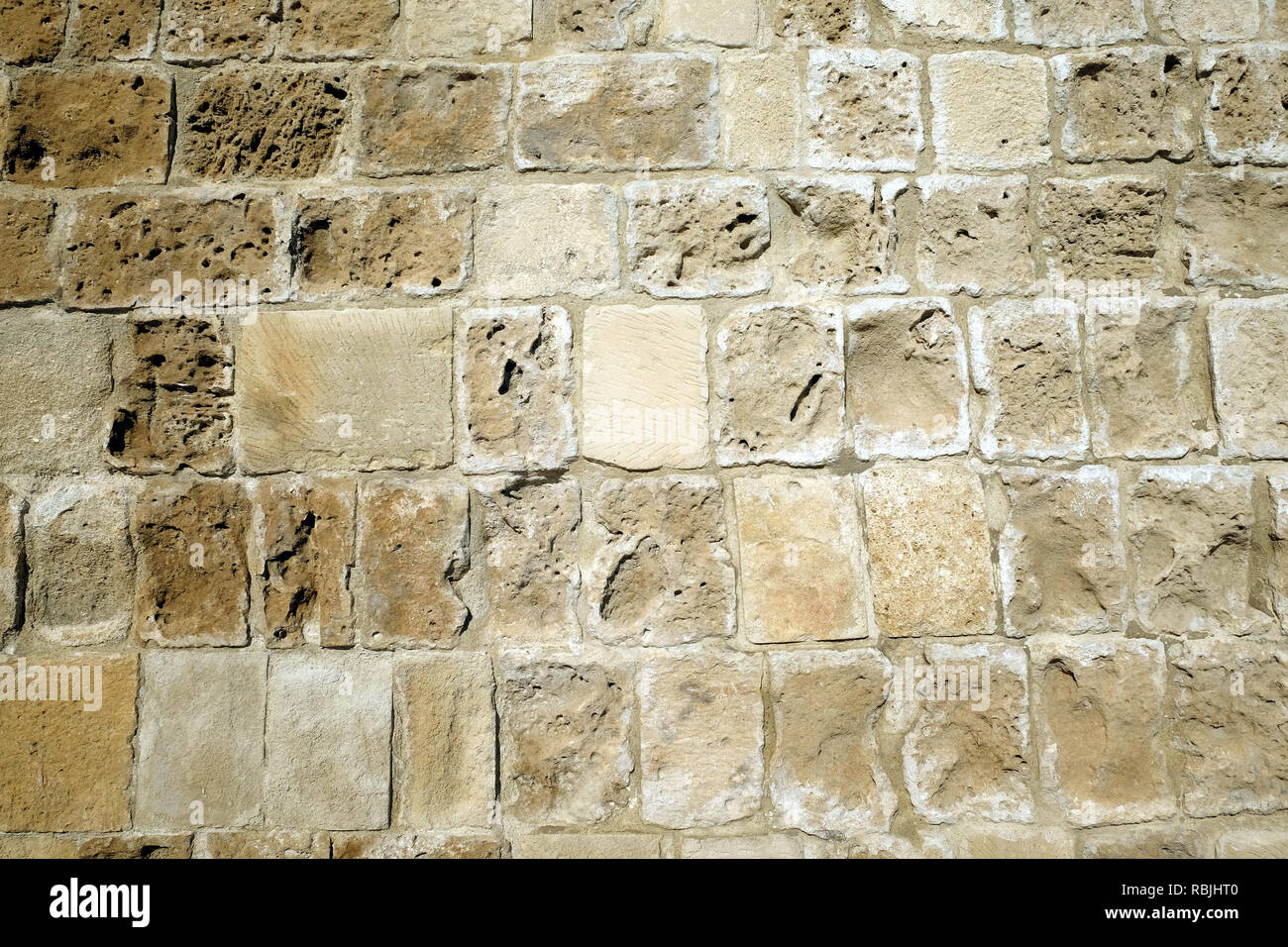 Vintage antique wall from old sandy limestone as background front view ...