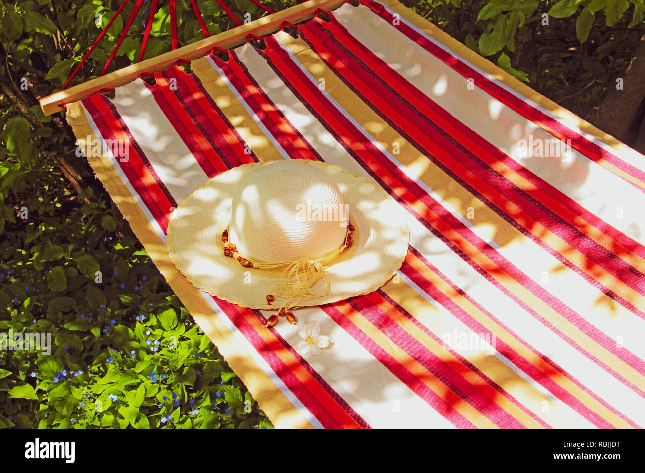 summer: hammock with a lady's sunhat hanging in a garden Stock Photo ...