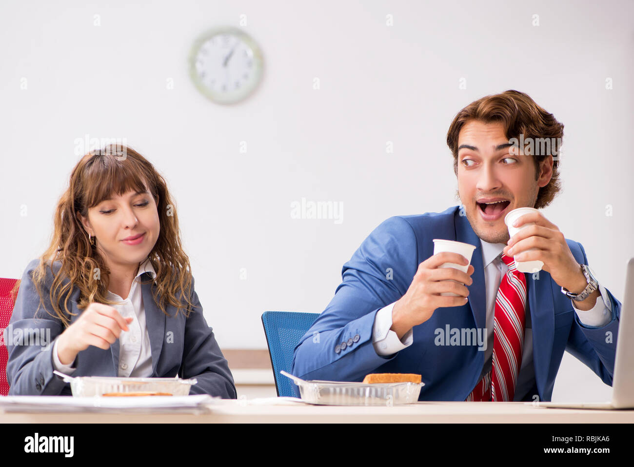 Two colleagues having lunch break at workplace Stock Photo - Alamy