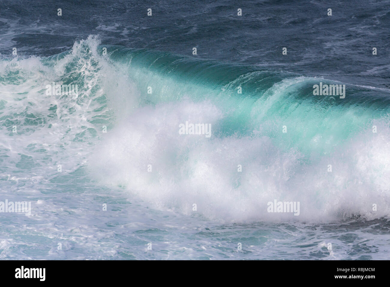 Emerald coloured breaking wave Stock Photo - Alamy