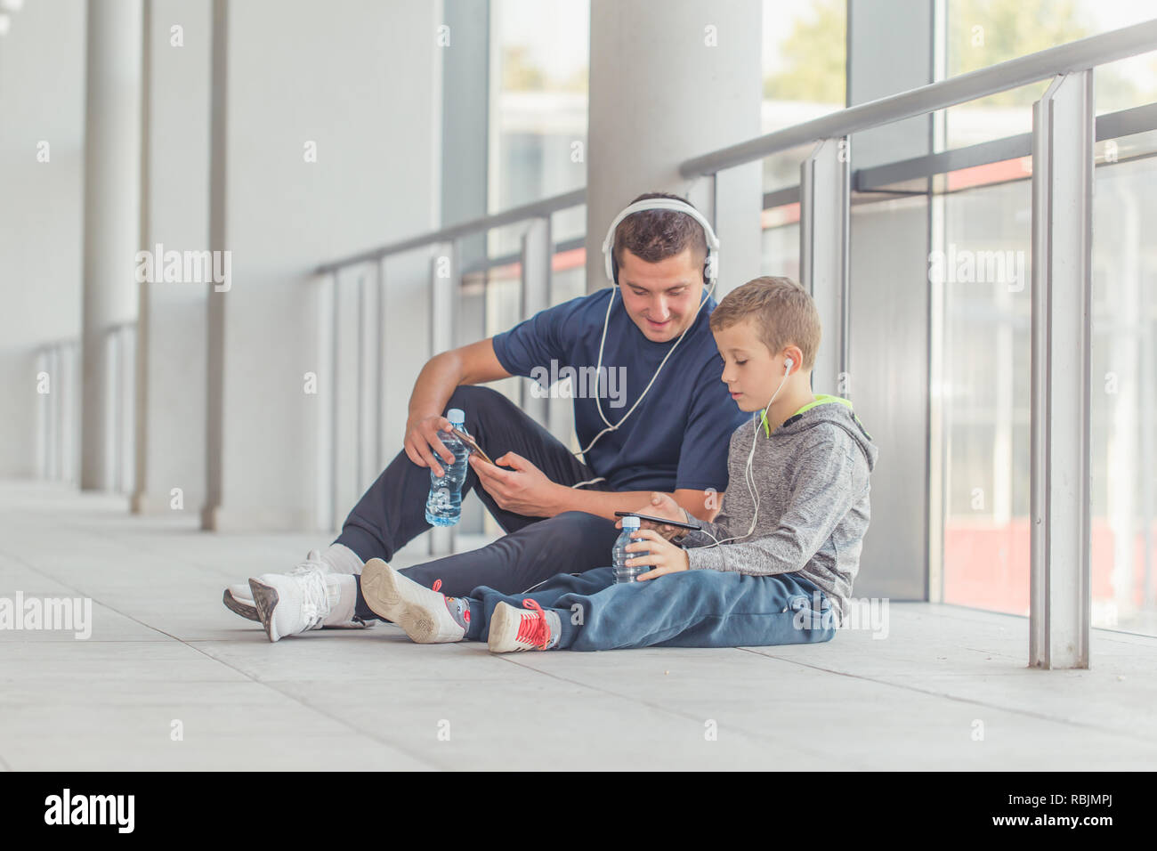 Little boy and his father taking a break and listening to the music ...