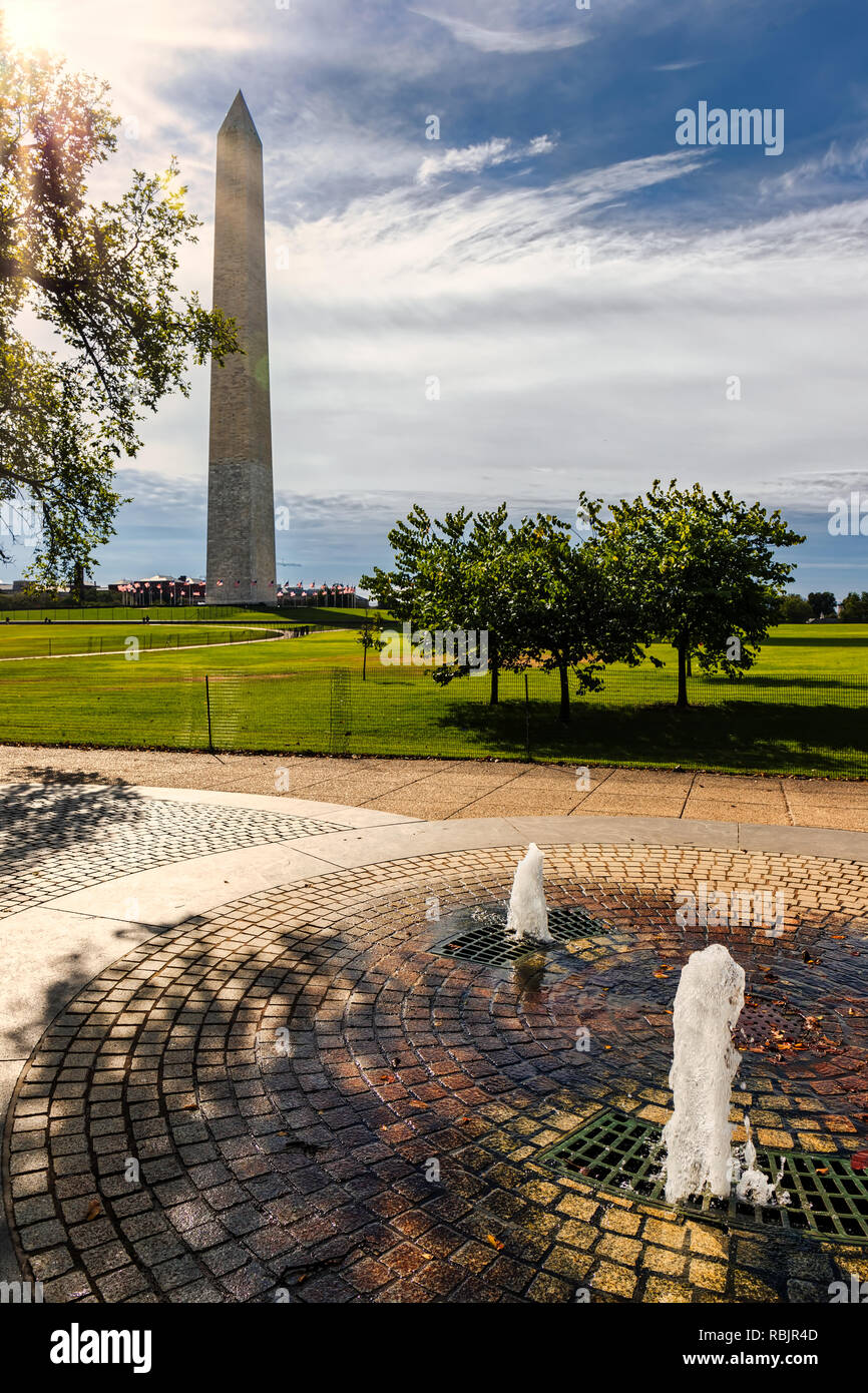 A fountain shoots water from the ground near the Washington Monument in ...