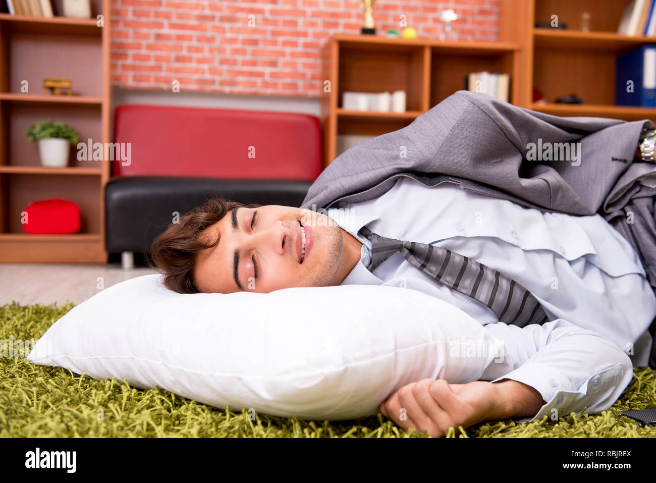 Young employee sleeping on the floor at office Stock Photo - Alamy