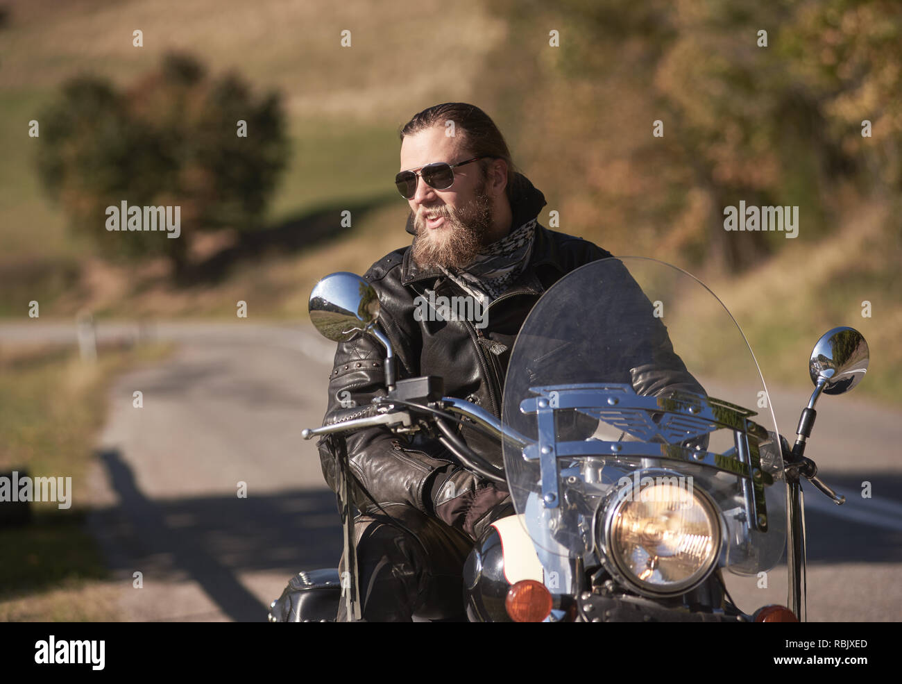 Portrait of handsome happy smiling bearded biker in black leather ...