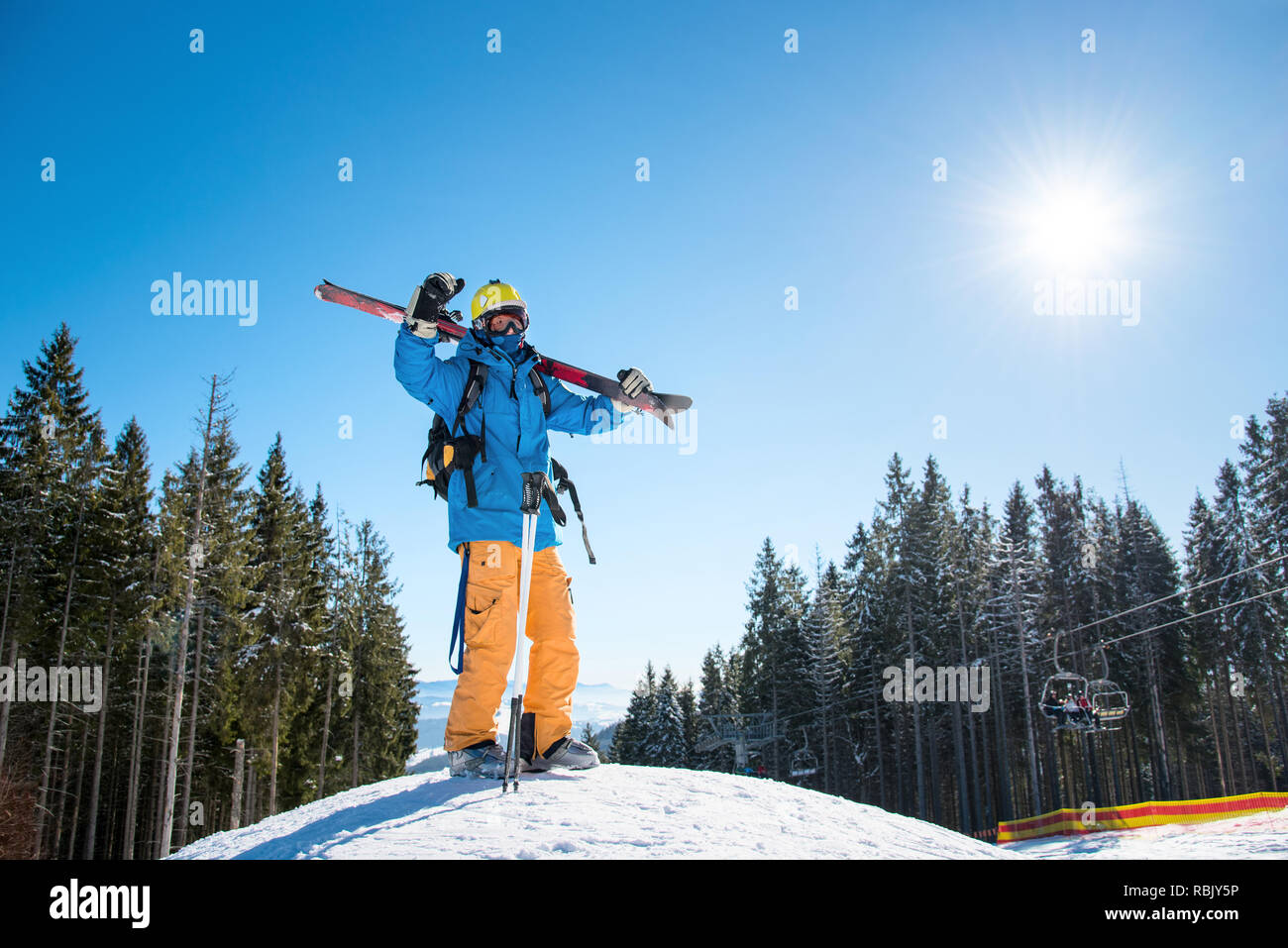 Full length shot of a skier standing on top of a snowy slope in the ...