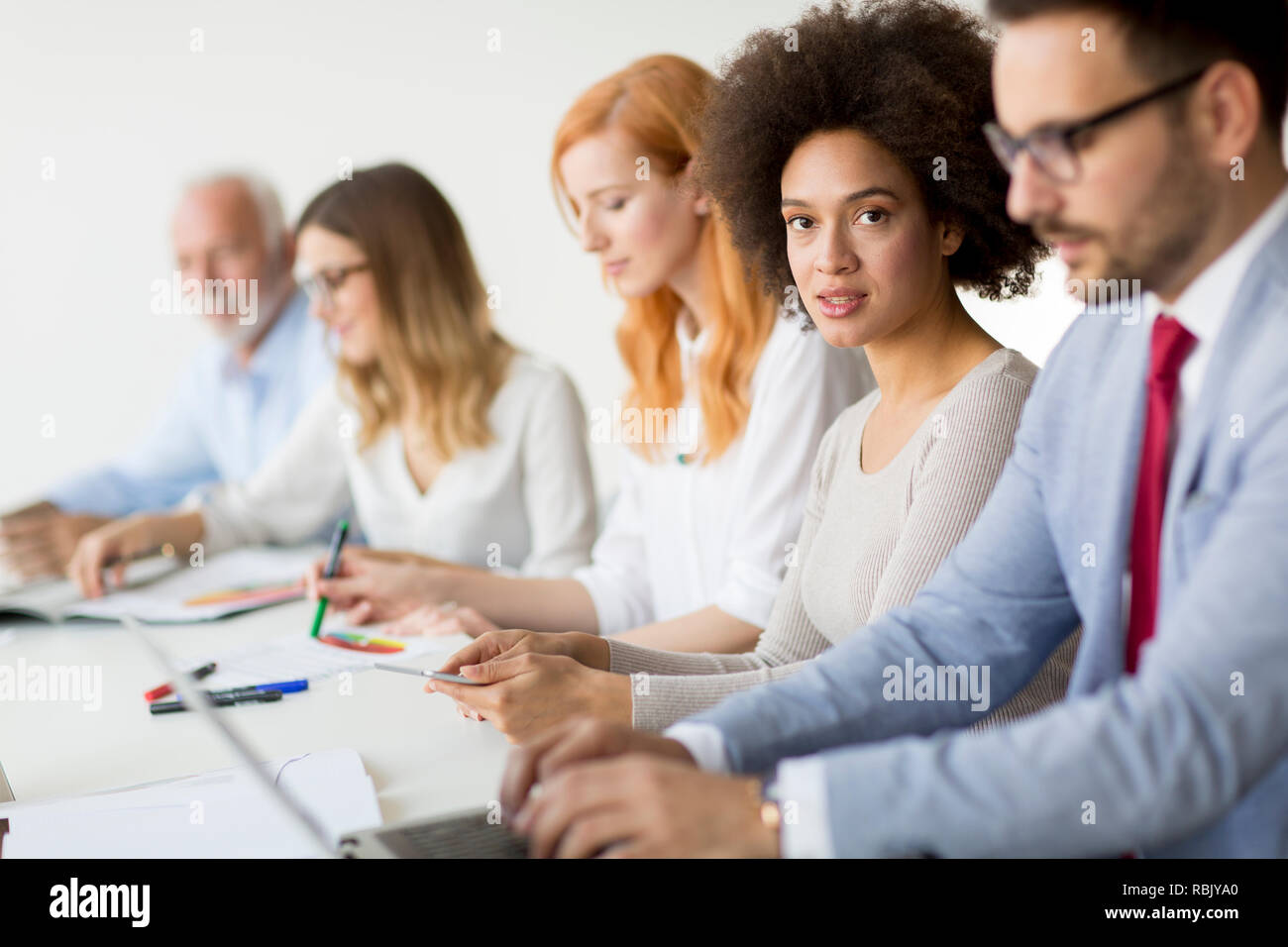 View of multiracial business people around table during staff meeting ...