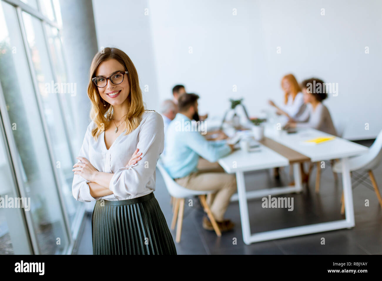Young pretty attractive female manager standing in modern office Stock ...