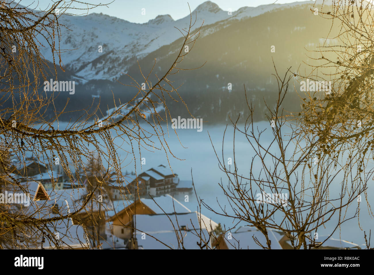 A village by a lake of clouds in Les Arcs, seen through the tree ...