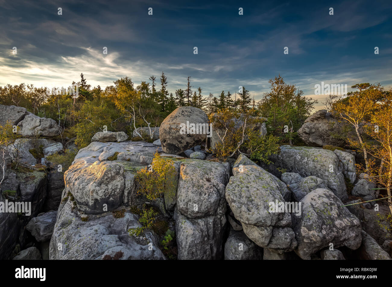 Rock massif with green trees and cloudy blue sky Stock Photo - Alamy