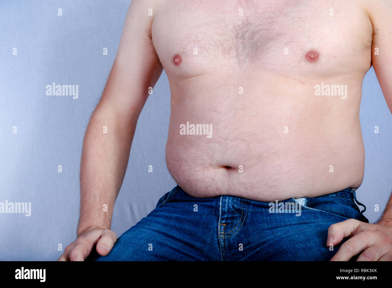 Overweight shirtless caucasian man sitting down Stock Photo - Alamy