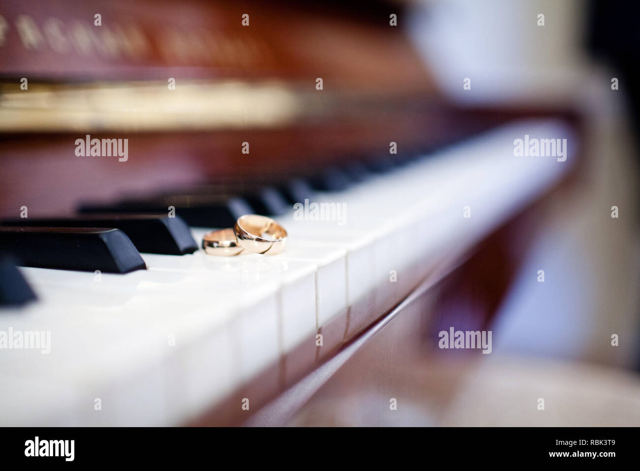 Close-up of a pair of wedding rings on the piano keys Stock Photo - Alamy