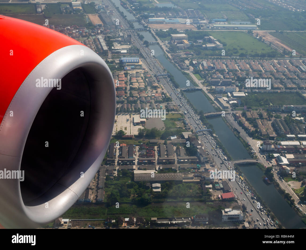 Jet engine of red airplane and the city aerial view from window of ...