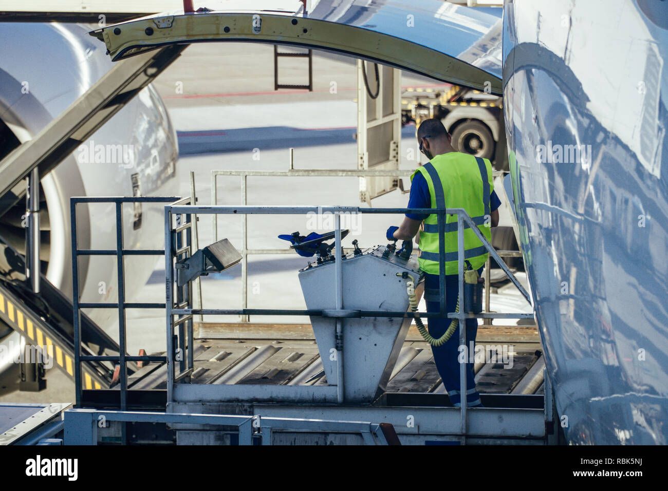 Airport employee handling cargo for loading an airplane Stock Photo - Alamy