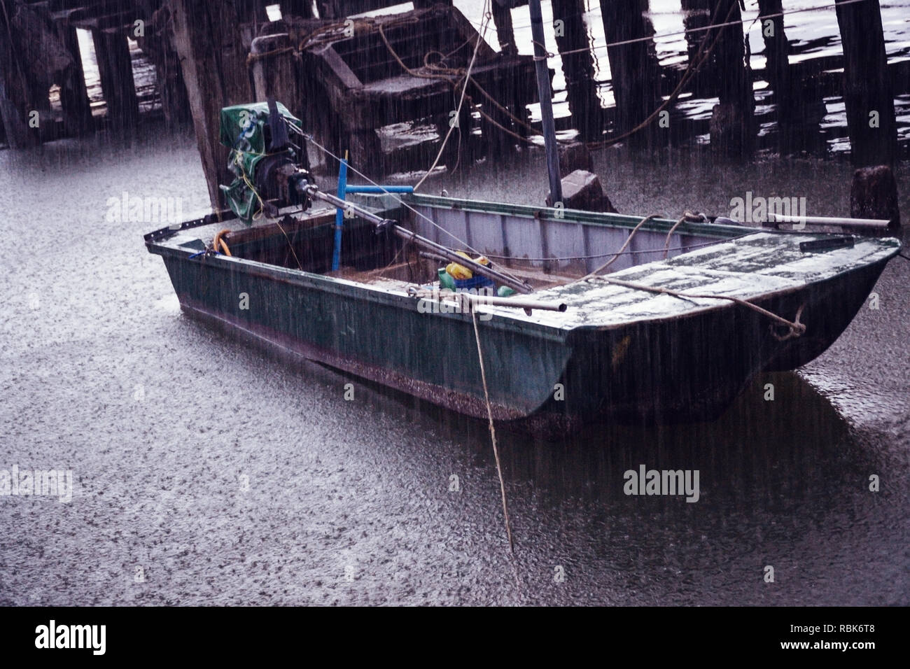 Old single motor boat in heavy rain at a port in Thailand Stock Photo ...