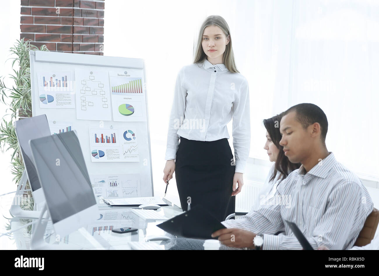 successful employee is standing by flipchart in office Stock Photo - Alamy