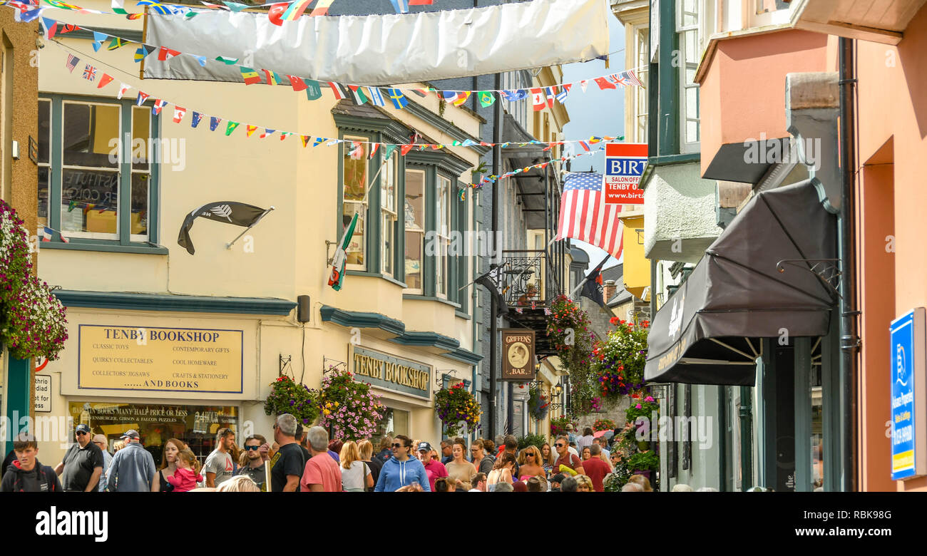 TENBY, PEMBROKESHIRE, WALES - AUGUST 2018: Crowds of people in one of ...