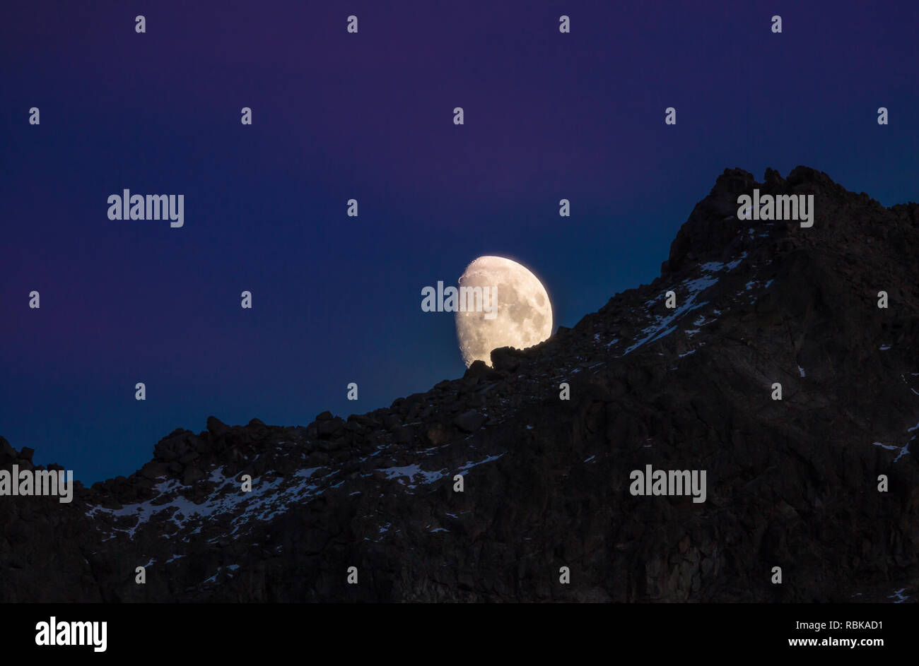 Rising moon behind a mountain Stock Photo - Alamy