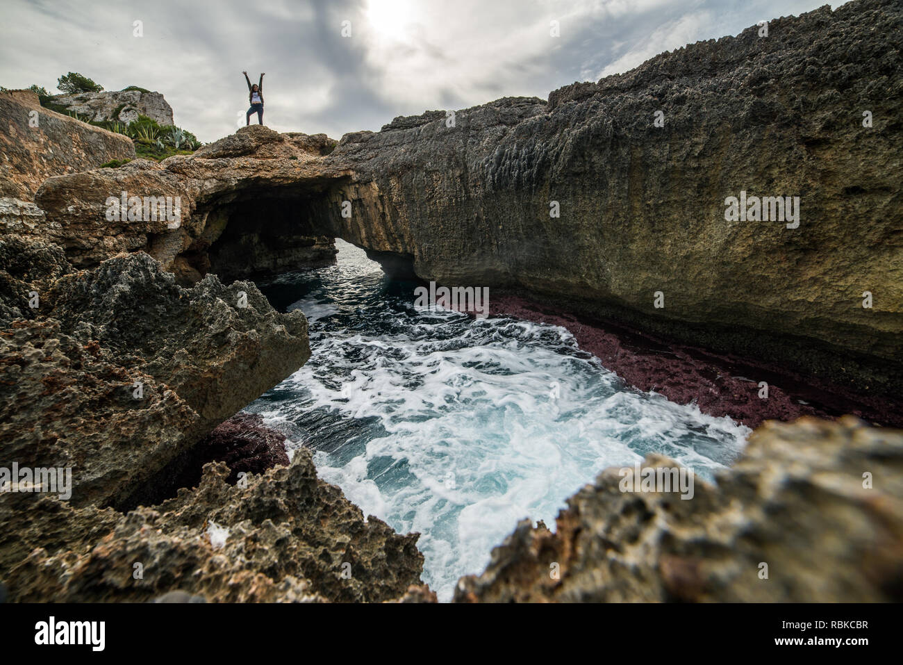 Traveler girl on a high cliff watching the beautiful views of Mallorca ...